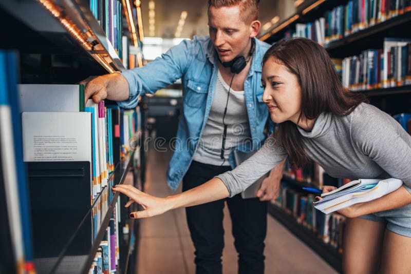Young Students Finding Reference Books in University Library Stock ...