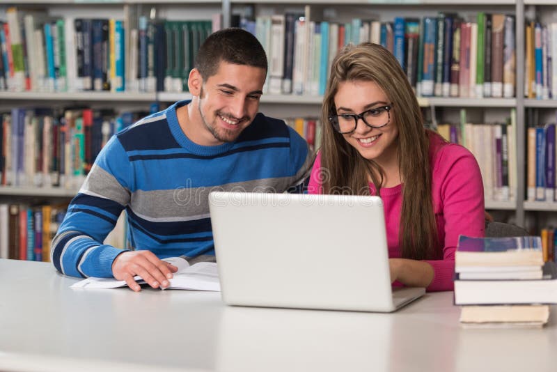 Two Students Learning in a Library with a Laptop Stock Photo - Image of ...