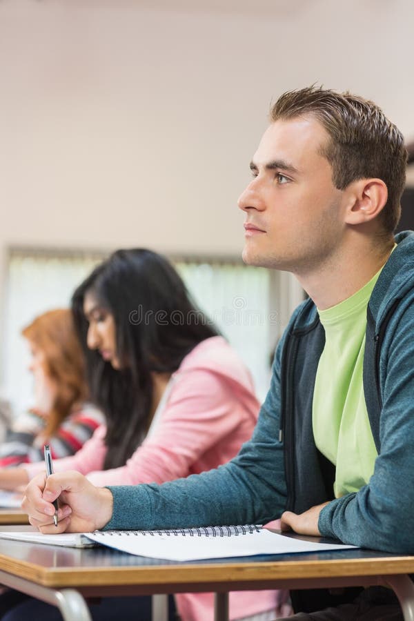 Young Students Writing Notes in Classroom Stock Photo - Image of ...