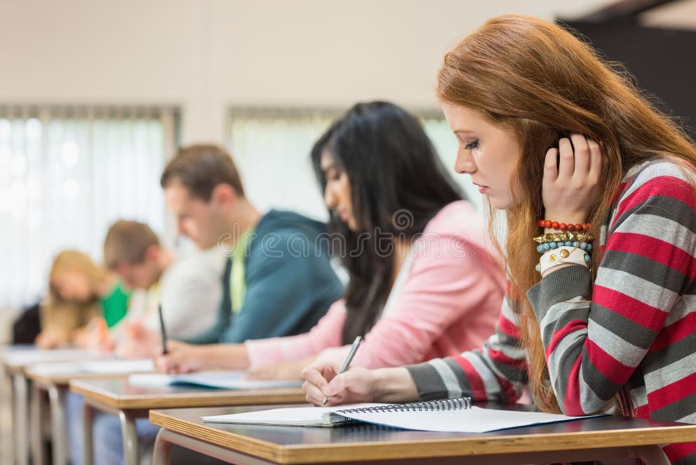 Young Students Writing Notes in Classroom Stock Photo - Image of casual ...