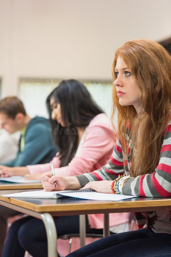 Young Students Writing Notes in Classroom Stock Photo - Image of four ...