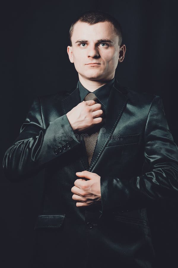 Young Stylish Guy Dressed in Black Classic Suit on a Black Background ... Young Stylish Guy Dressed in Black Classic Suit on a Black Background ...