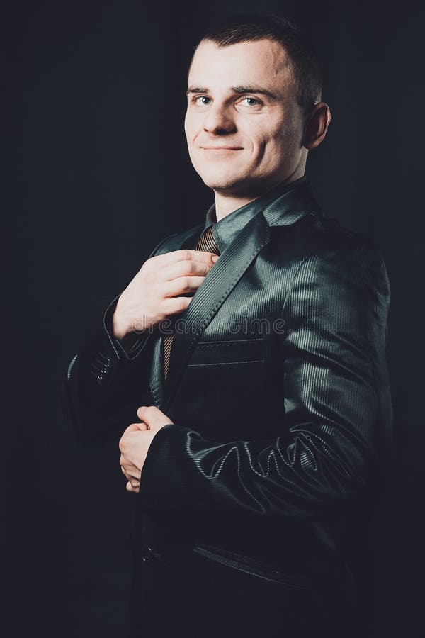 Young Stylish Guy Dressed in Black Classic Suit on a Black Background ... Young Stylish Guy Dressed in Black Classic Suit on a Black Background ...