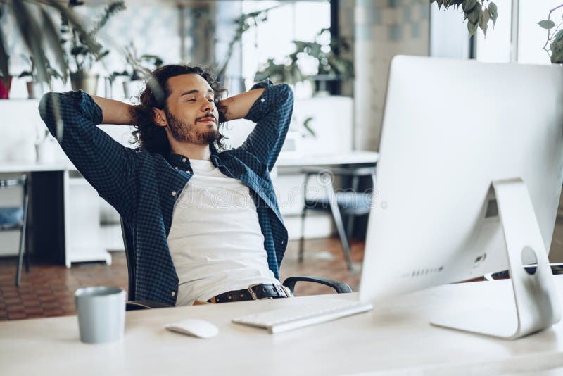 Young Businessman Sitting in Office with Hands Behind His Head ...