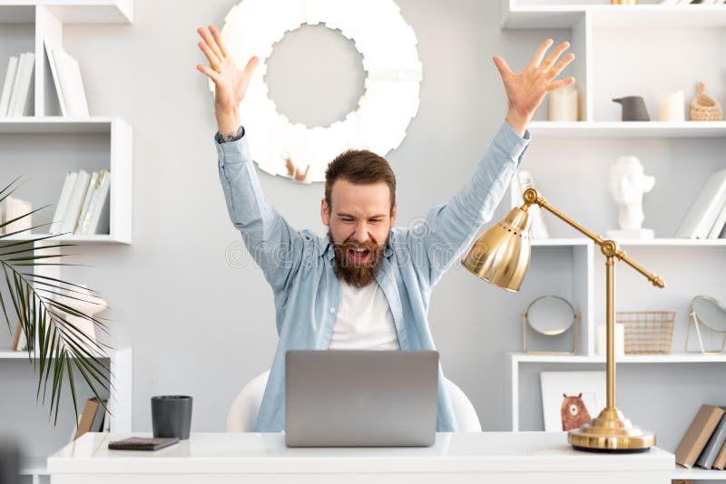 Young Successful Man Sitting at the Table Raising His Hands Stock Photo ...