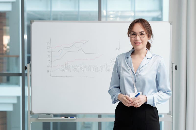 Young Successful Teacher of Economics Standing by Whiteboard with ...