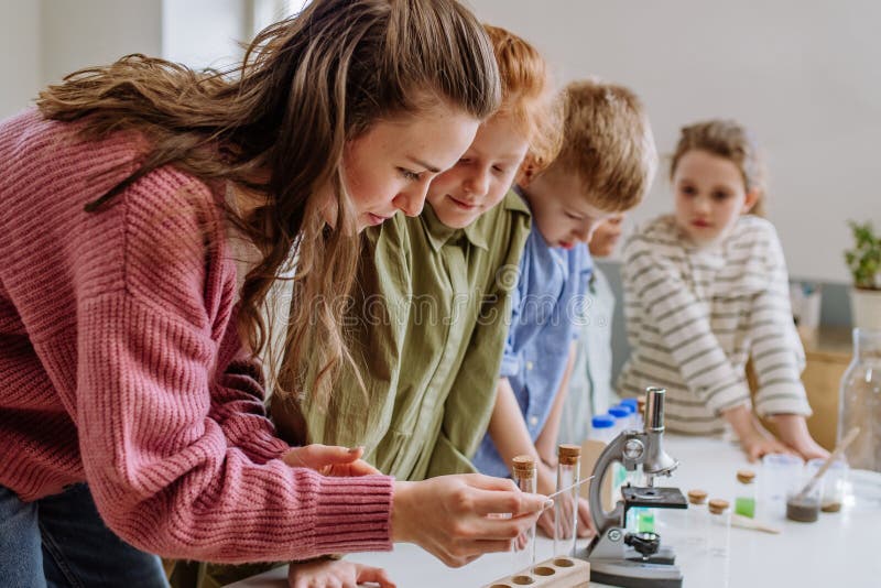 Young Teacher Doing Chemistry Experiment with Pupils during Science ...