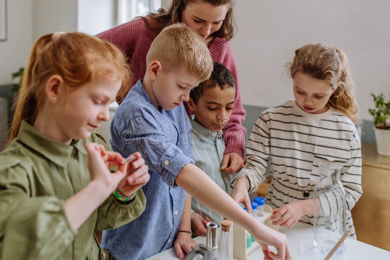 Young Teacher Doing Chemistry Experiment with Pupils during Science ...