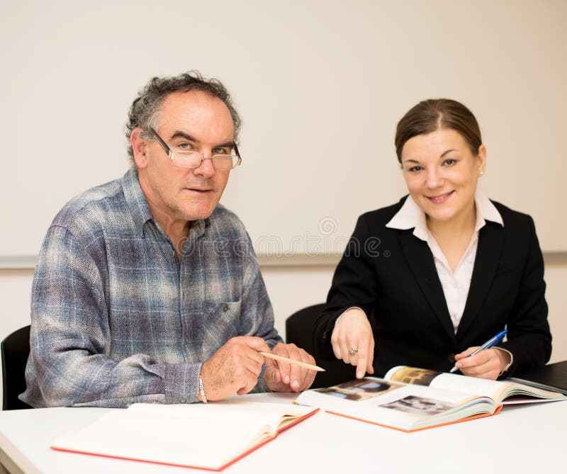 Young Teacher Explaining Somethng To Eldery Man. Intergenerational ...
