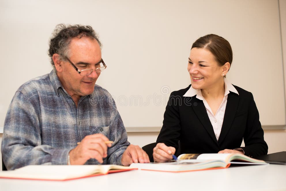 Young Teacher Explaining Somethng To Eldery Man. Intergeneration Stock ...
