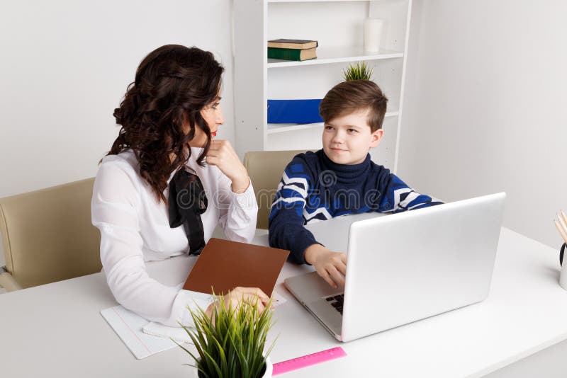 Young Teacher with Kid Doing Homework on a Computer. Tutor Help. Stock ...