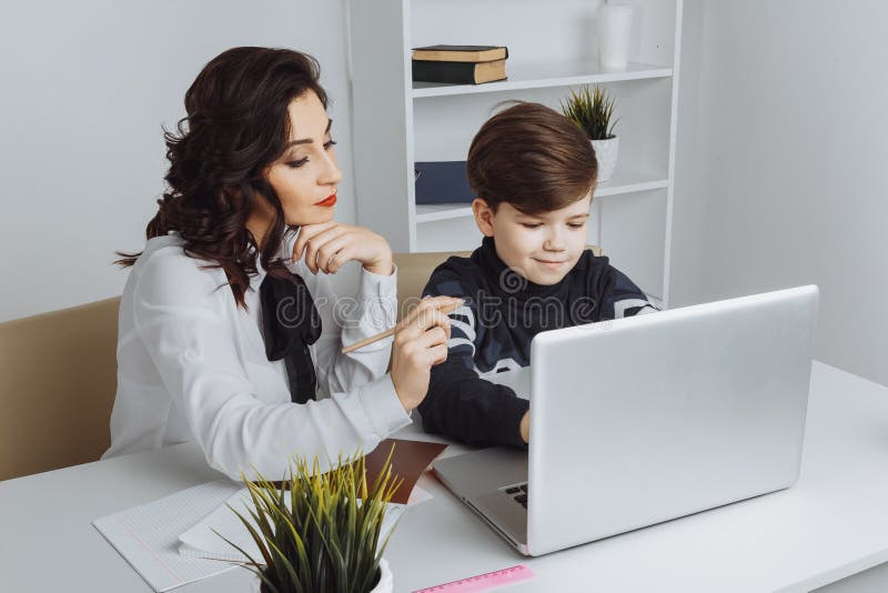 Young Teacher with Kid Doing Homework on a Computer. Tutor Help. Stock ...