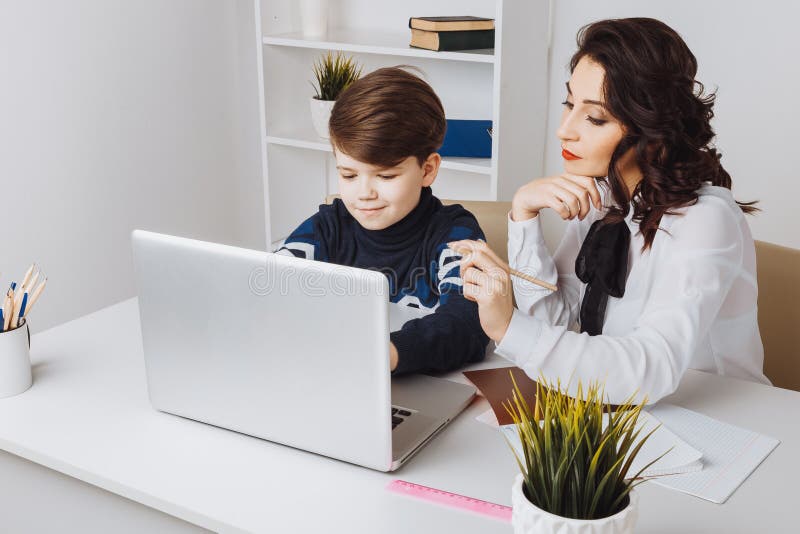 Young Teacher with Kid Doing Homework on a Computer. Tutor Help. Stock ...