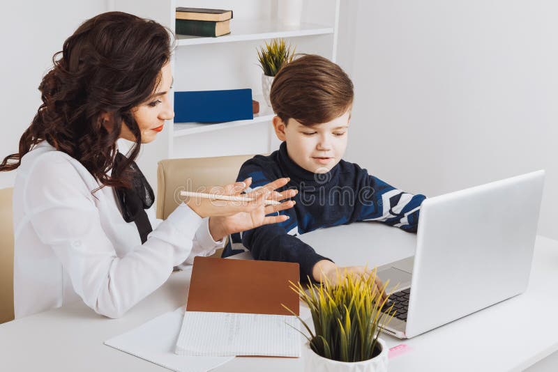 Young Teacher with Kid Doing Homework on a Computer. Tutor Help. Stock ...