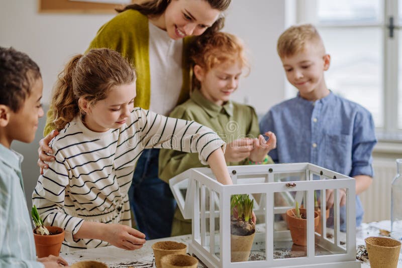 Young Teacher Learning Pupils How To Take Care about Plants. Stock ...