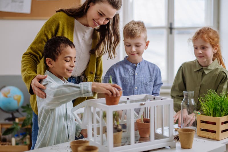Young Teacher Learning Pupils How To Take Care about Plants. Stock ...