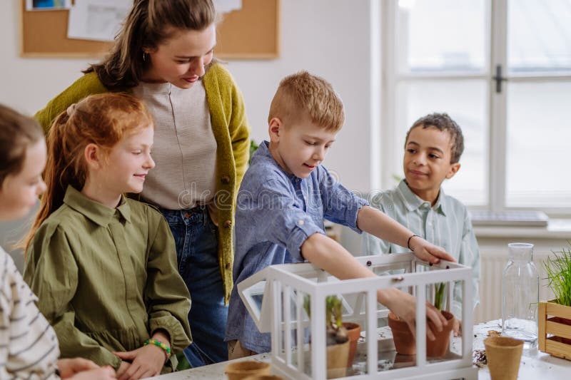 Young Teacher Learning Pupils How To Take Care about Plants. Stock ...