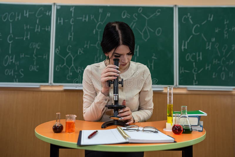 Young Teacher with Microscope, Book and Test Tubes in a Classroom Stock ...