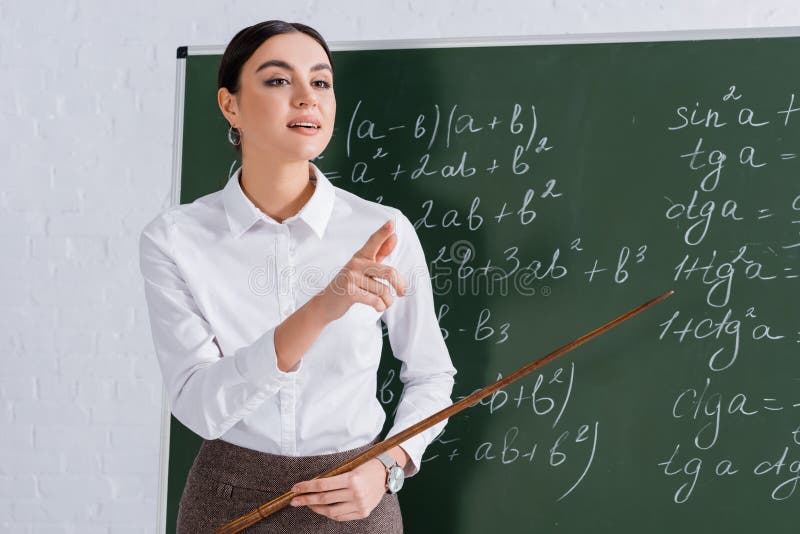 Young Teacher with Pointer Pointing Away Stock Photo - Image of gesture ...