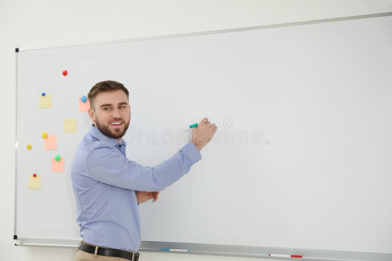 Young Teacher Writing on Whiteboard in Classroom. Space for Text Stock ...