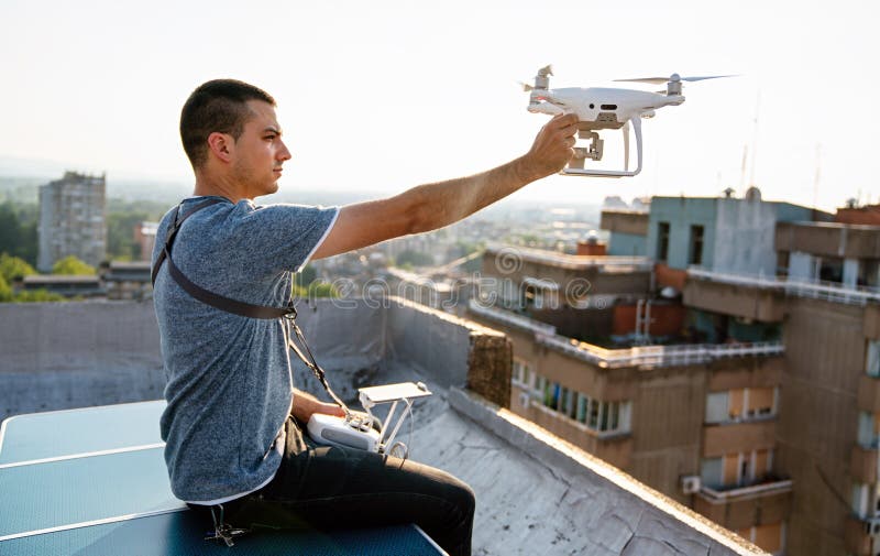 Young Technician Flying UAV Drone with Remote Control on Rooftop Stock ...