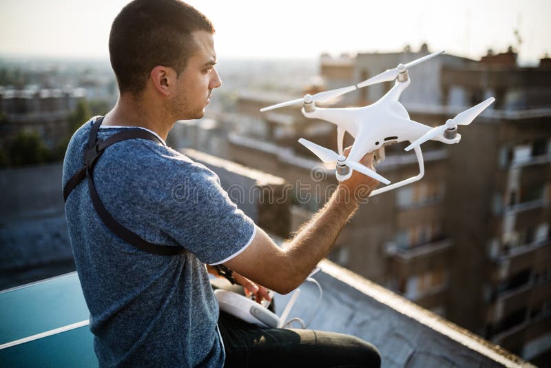 Young Technician Flying UAV Drone with Remote Control on Rooftop Stock ...