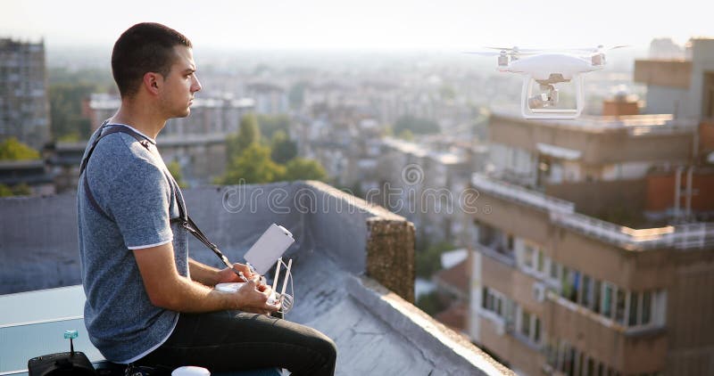 Young Technician Flying UAV Drone with Remote Control on Rooftop Stock ...