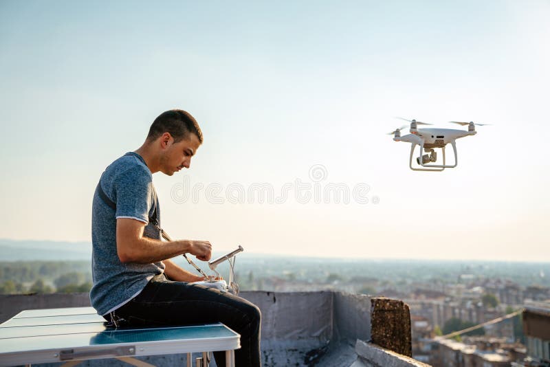 Young Technician Man Flying UAV Drone with Remote Control in City Stock ...