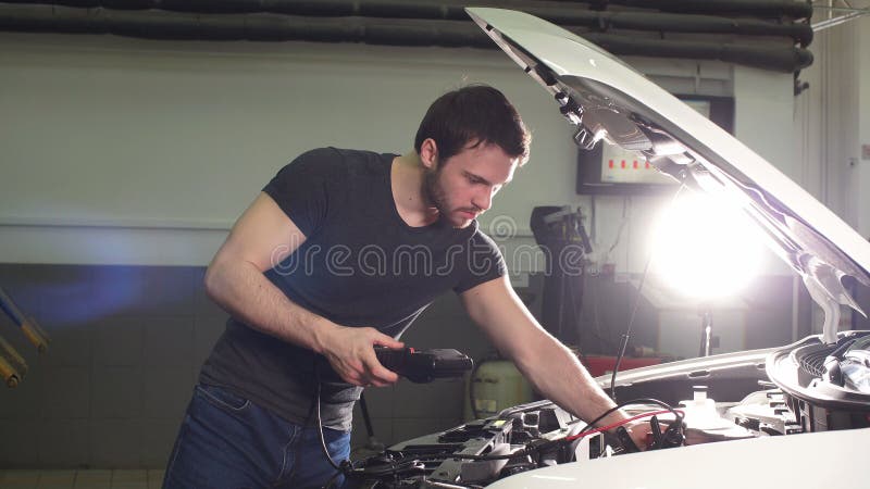 Young Technician Man Making Engine Service of Car in Garage. Stock ...