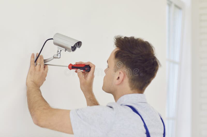 Young Technician Man in Uniform Installing Surveillance CCTV Camera on ...