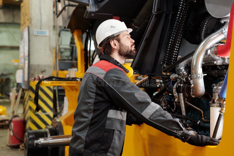 Young Technician or Repairman in Hardhat Standing by Industrial Machine ...