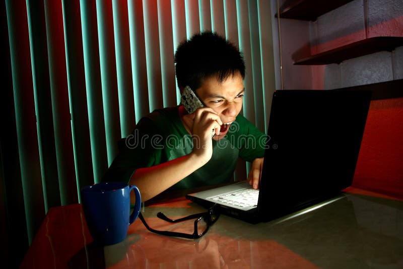 Young Teen Using a Cellphone or Smartphone in Front of a Laptop ...