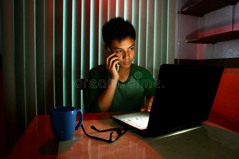 Young Teen Using a Cellphone or Smartphone in Front of a Laptop ...