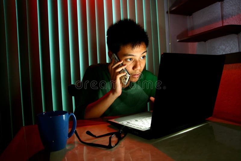 Young Teen Using a Cellphone or Smartphone in Front of a Laptop ...