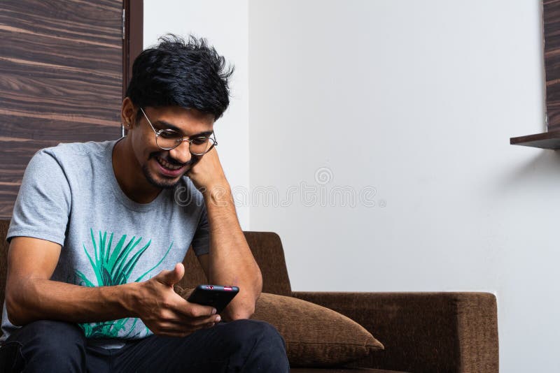 Young Teenage Boy Using Mobile Phone Sitting on Sofa Stock Photo ...