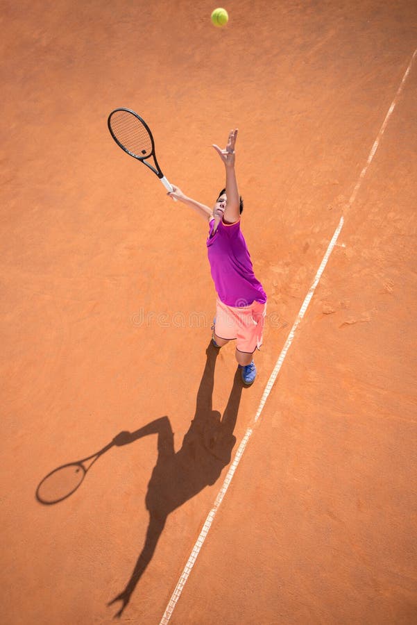 Young Tennis Player Serving the Ball with High Impact Stock Photo ...