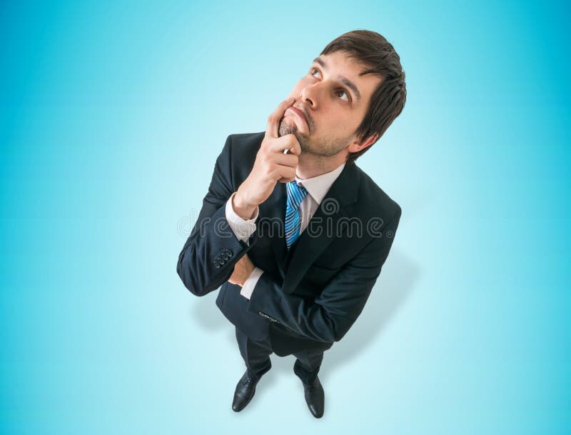 Young Thoughtful Businessman is Thinking on Blue Background Stock Photo ...