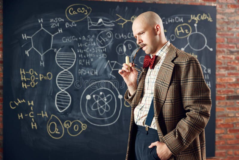 Young Thoughtful Man, Scientist Standing at Blackboard with Formulas ...