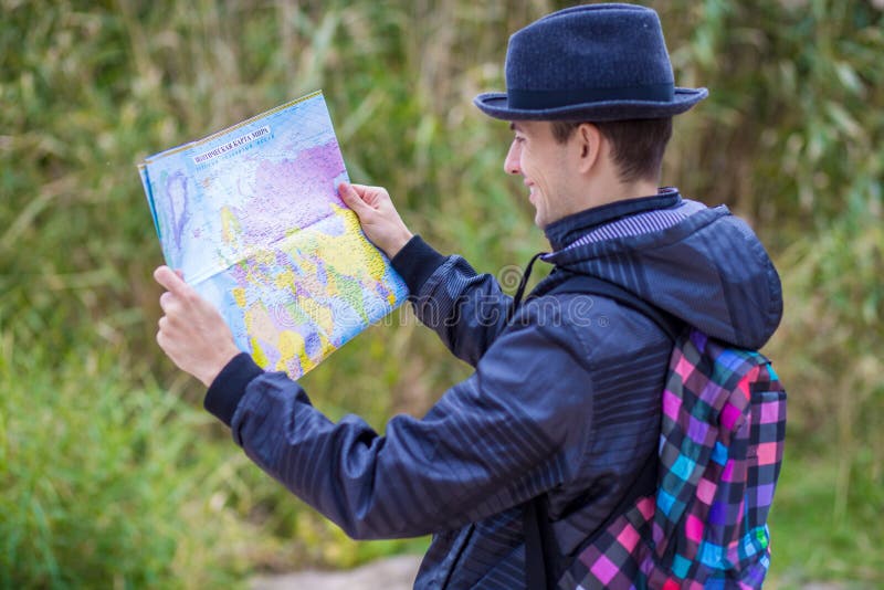 Young man holding a map stock photo. Image of atlas - 101940492