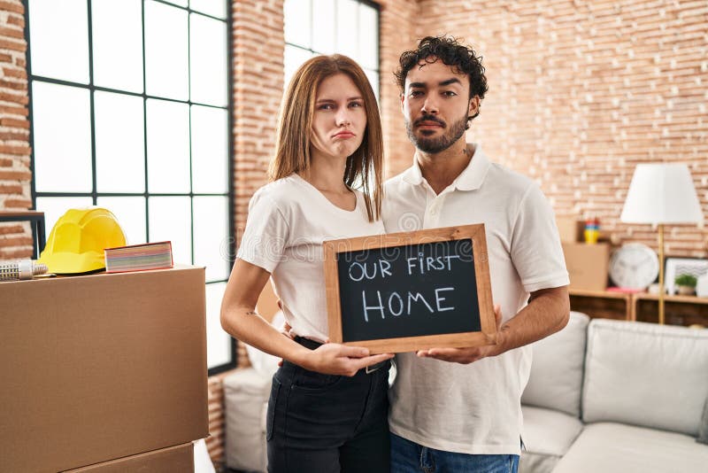 Young Two People Holding Blackboard with First Home Text Depressed and ...