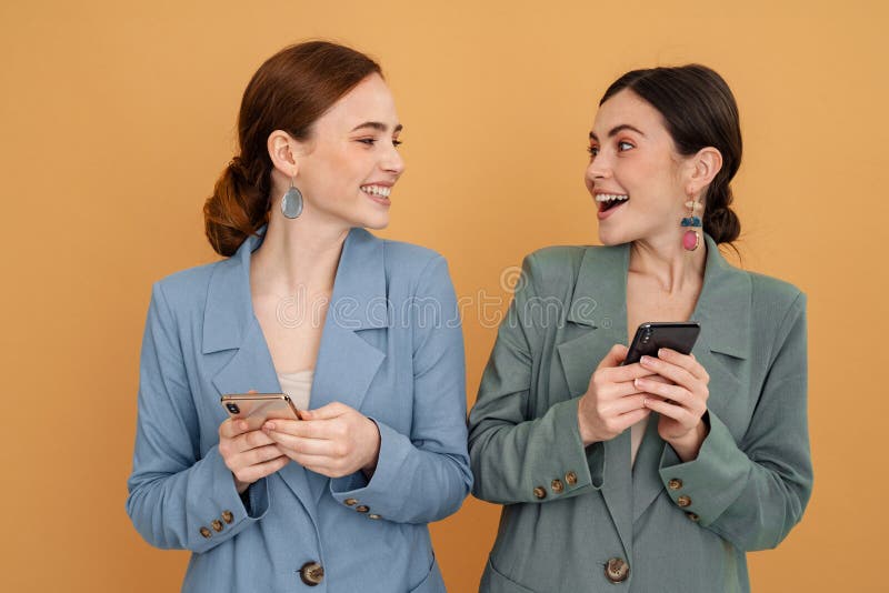 Young Two Women Laughing While Using Mobile Phones Stock Image Image