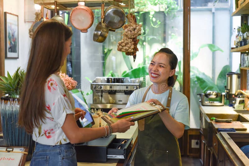 Young Vietnamese Waitress Working with Check Out Machine and Customers ...