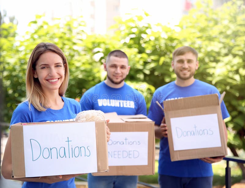 Young Volunteers Holding Boxes with Donations for Poor People Stock ...