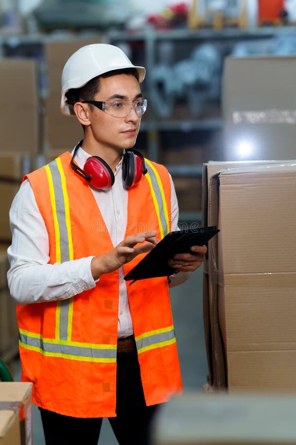 Young Warehouse Worker in Safe Clothes Uses Tablet. Stock Photo - Image ...