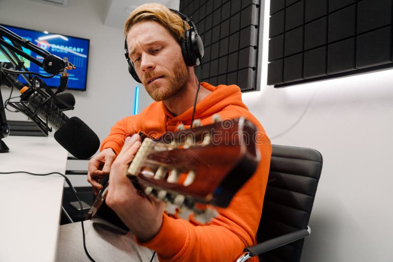 Young White Man Using Microphone while Playing Guitar in Radio Studio ...