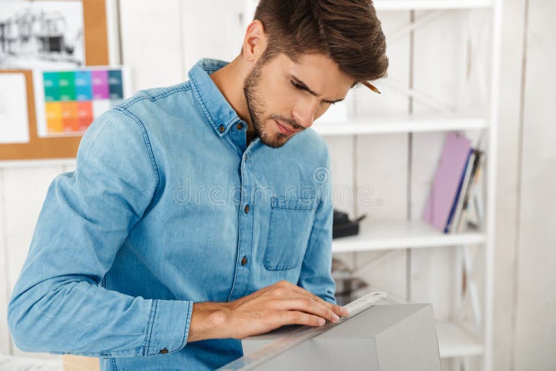 Young White Man Working with Material Sample in Office Stock Photo ...