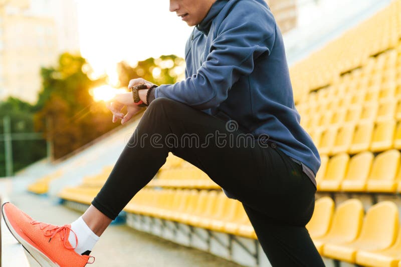 Young White Runner Using Smartwatch while Working Out on Stadium Stock ...