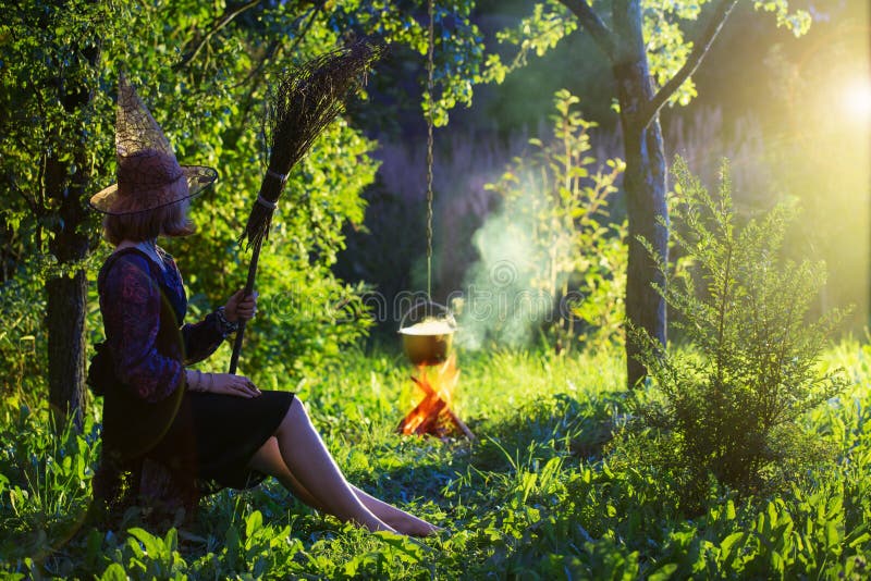 Witch by Fire in Magic Forest Makes in Cauldron Magic Potion Stock ...
