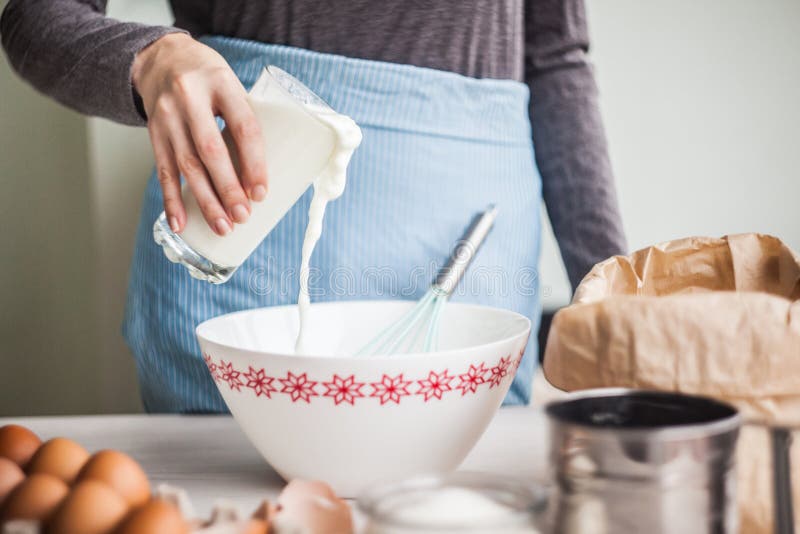 Young Woman Adding a Milk To the Egg Mixture.making Dough for the Cake ...