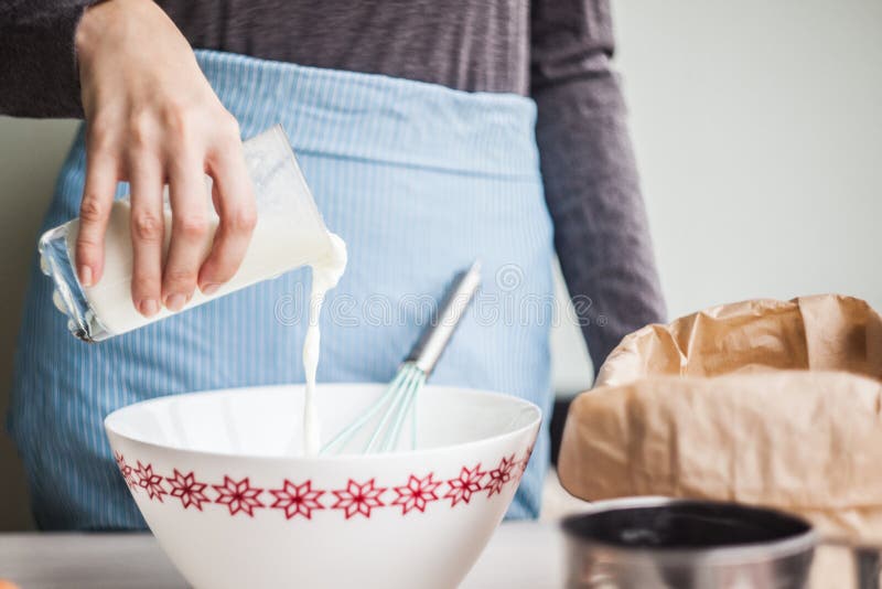 Young Woman Adding a Milk To the Egg Mixture.making Dough for the Cake ...